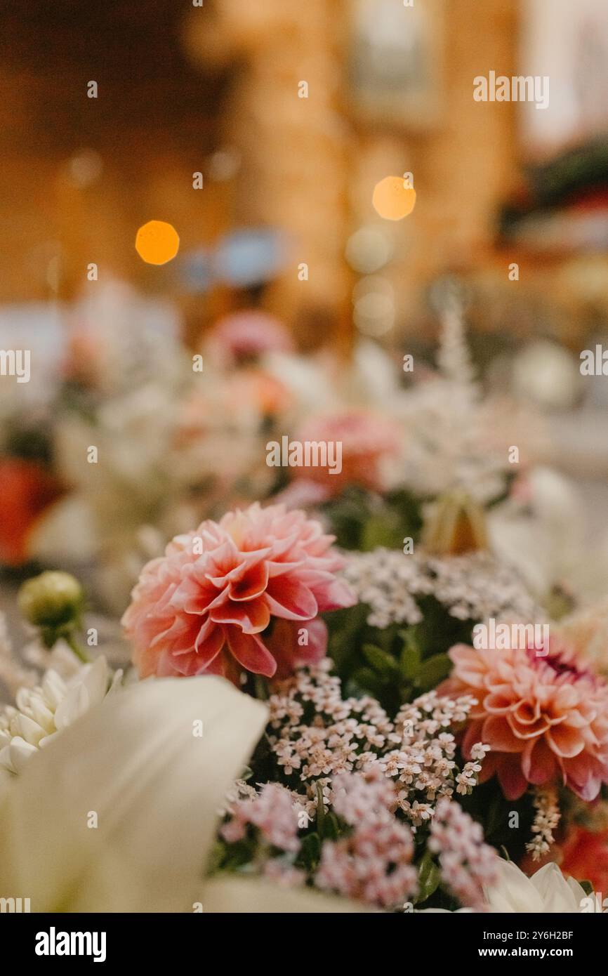 A vibrant bouquet of lilies and dahlias adorns the altar of a wooden ...