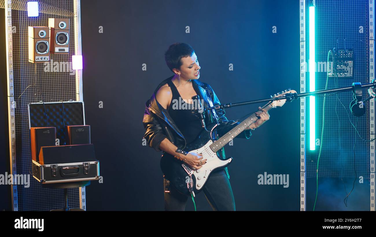 Female artist rocking the stage with her electric guitar in a dark ...