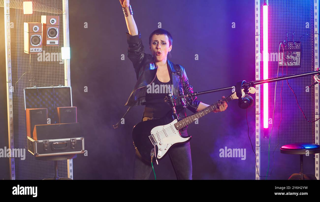 Punk rock girl with a grunge edgy style performing with a bass guitar ...