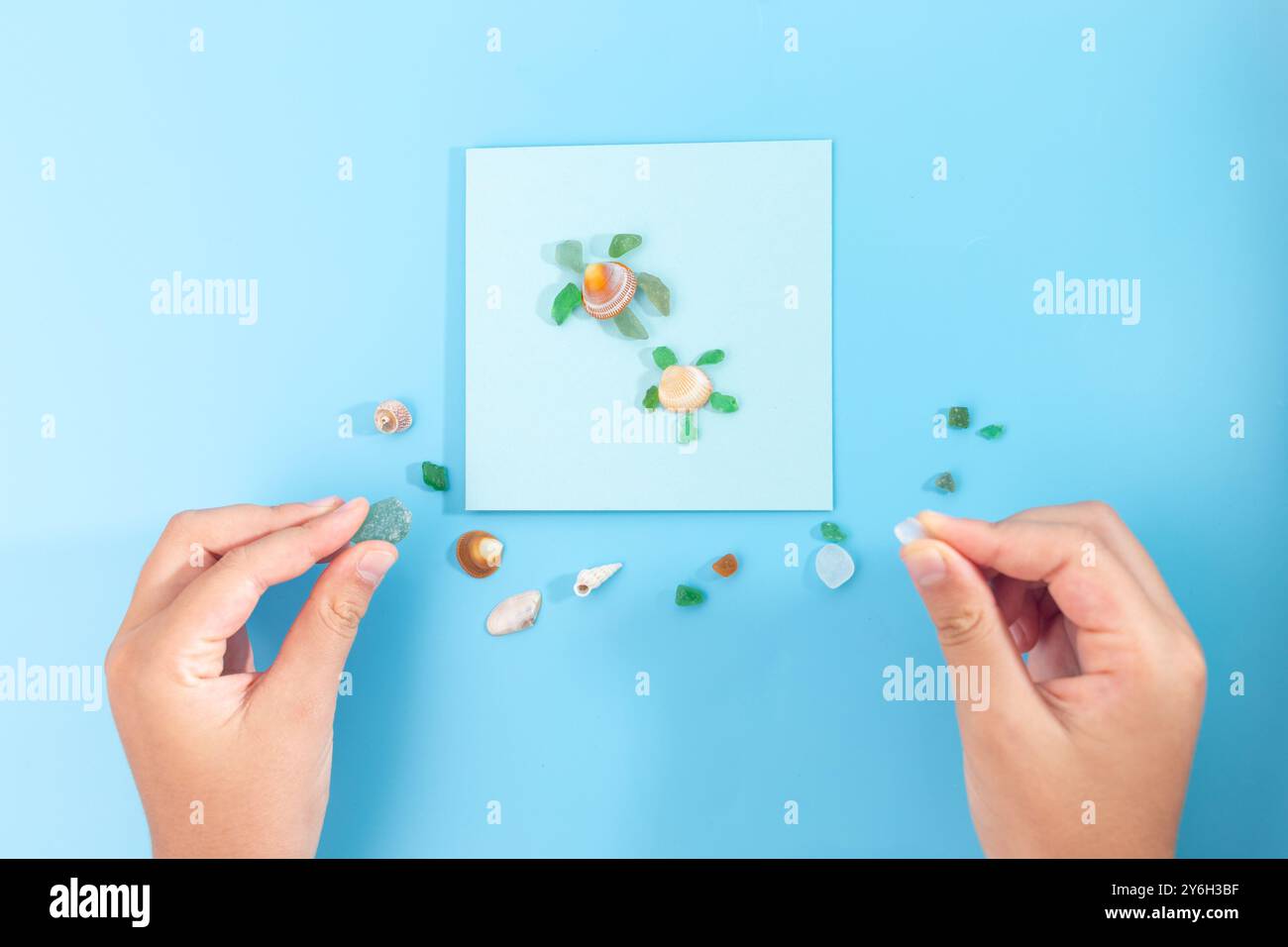 Artistic flat lay composition on blue background, hands adjusting ...