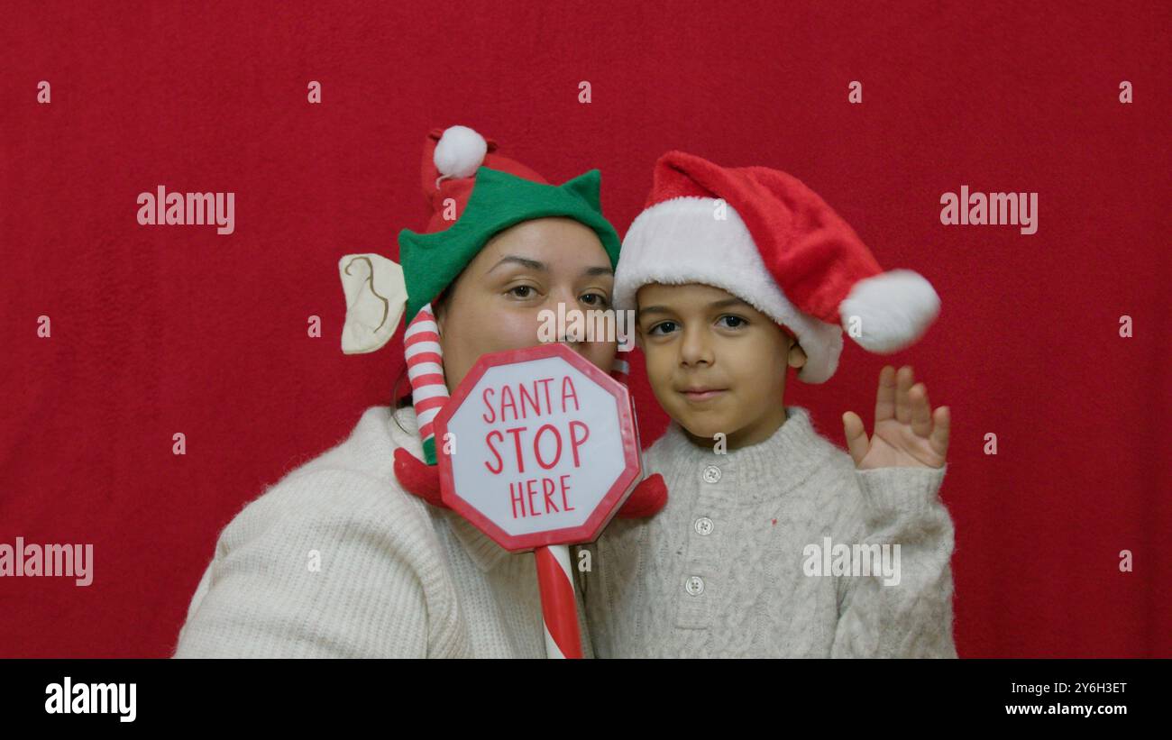 Mom and son holding santa stop here sign, Family bonding during the ...