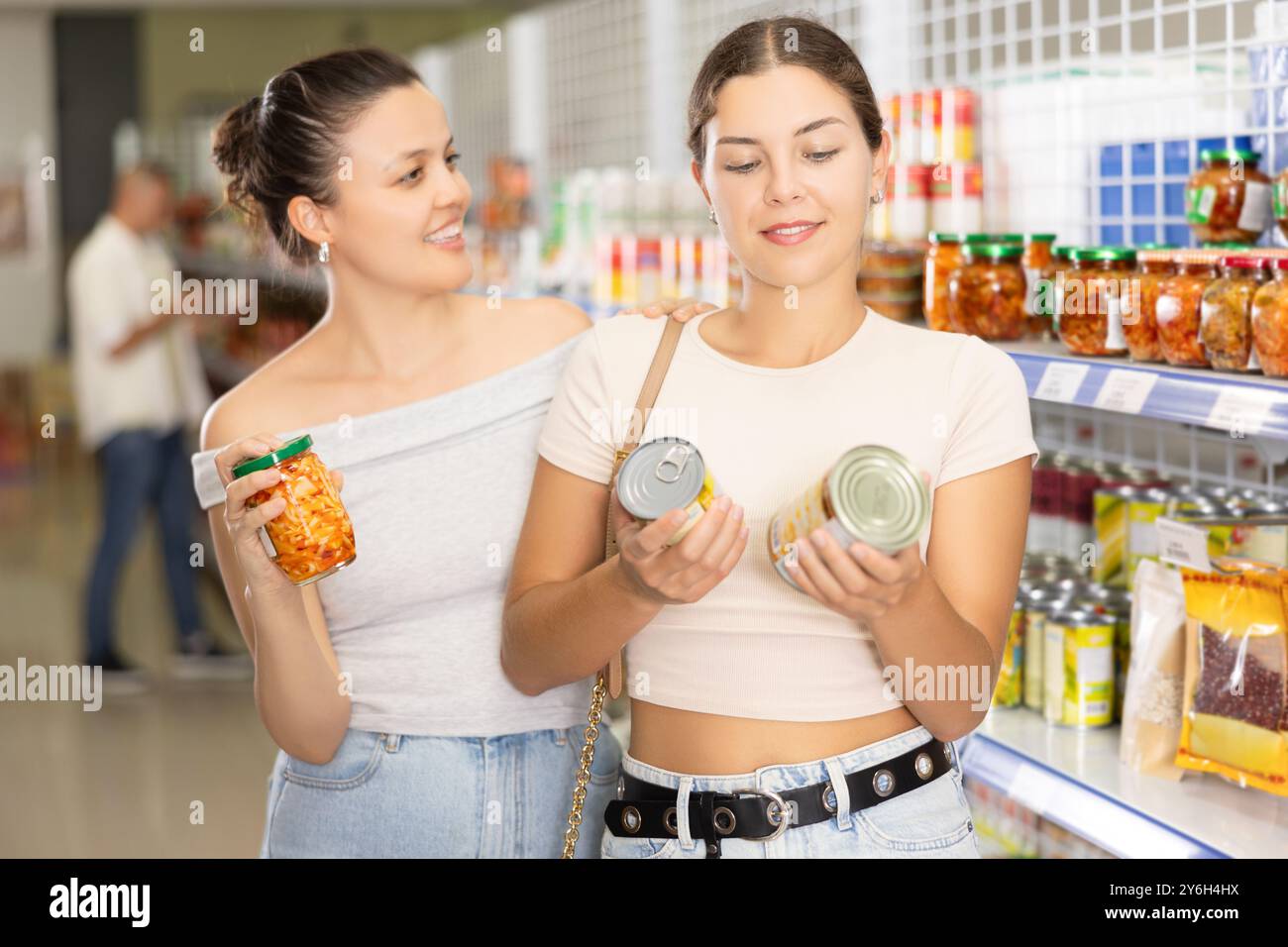 Cheerful young women selecting Asian pickles in supermarket Stock Photo ...