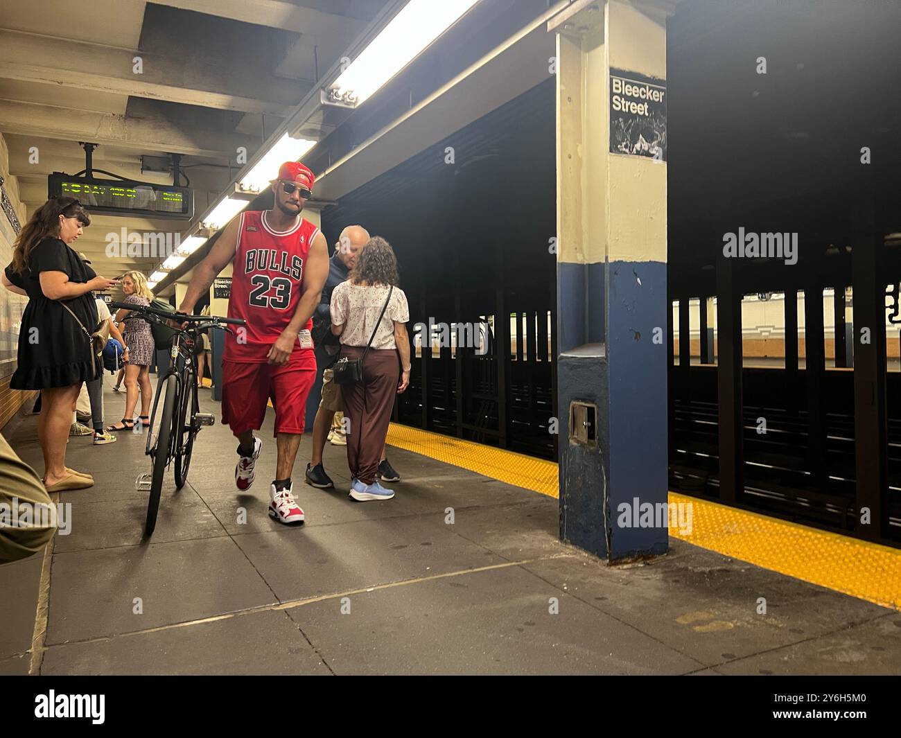 Man with his bicycle on a subway platform wearing the well known Bulls ...