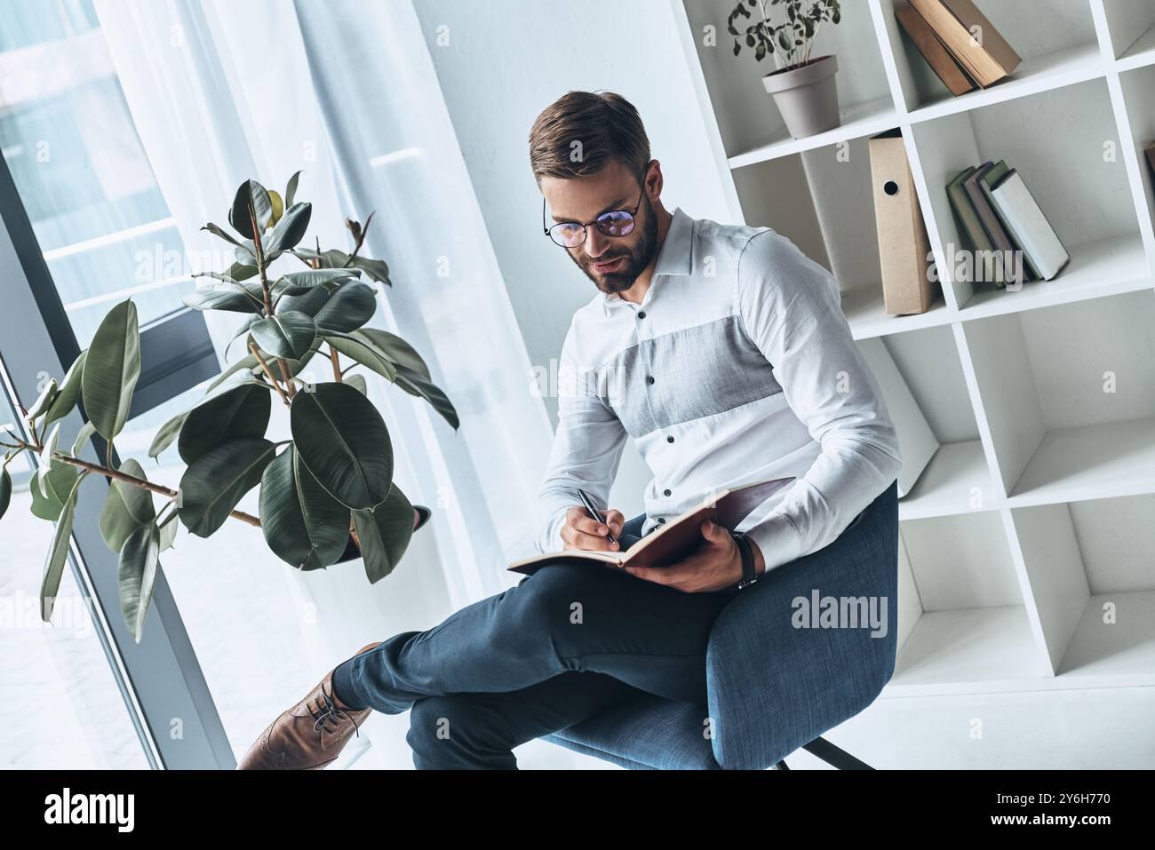Young and smart. Handsome young man is smart casual wear writing ...