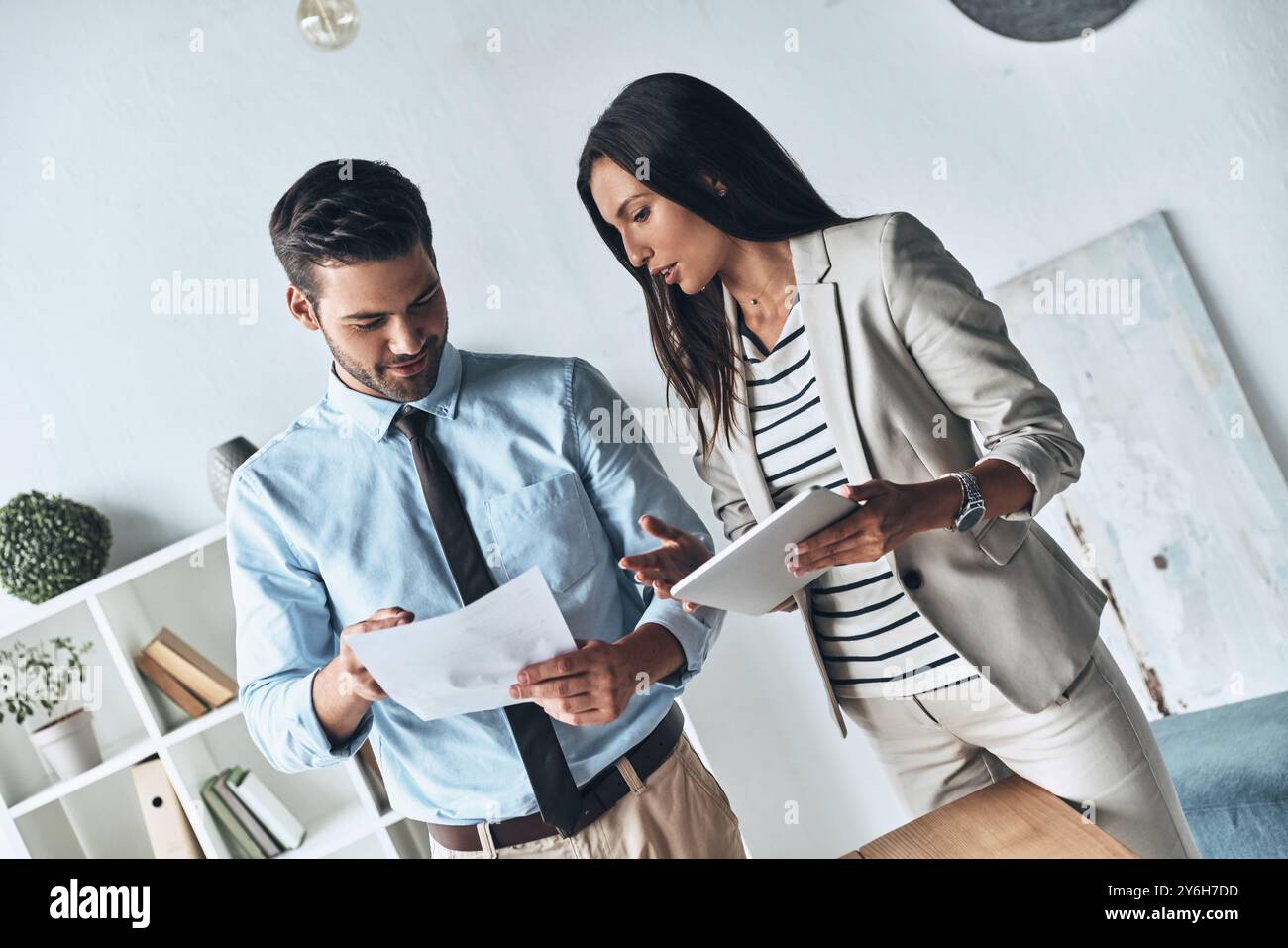 Brainstorming together. Two young colleagues in smart casual wear ...