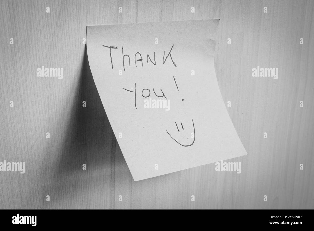 A sticky note hanging on the wall, with the text Thank You on it Stock ...