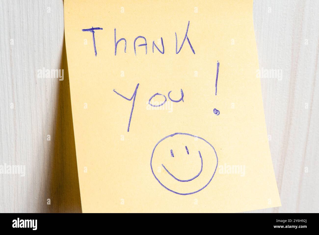 A sticky note hanging on the wall, with the text Thank You on it Stock ...