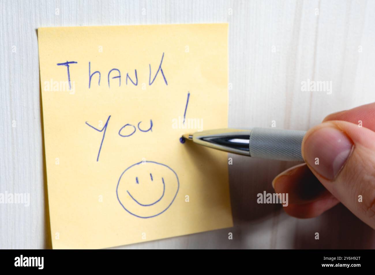 A sticky note hanging on the wall, with the text Thank You on it Stock ...