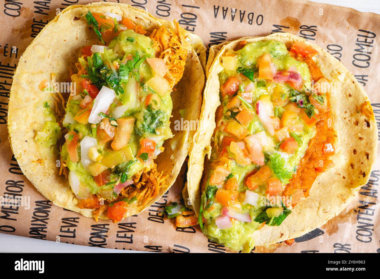Two soft taco's with chicken and beans. laying down on brown paper ...