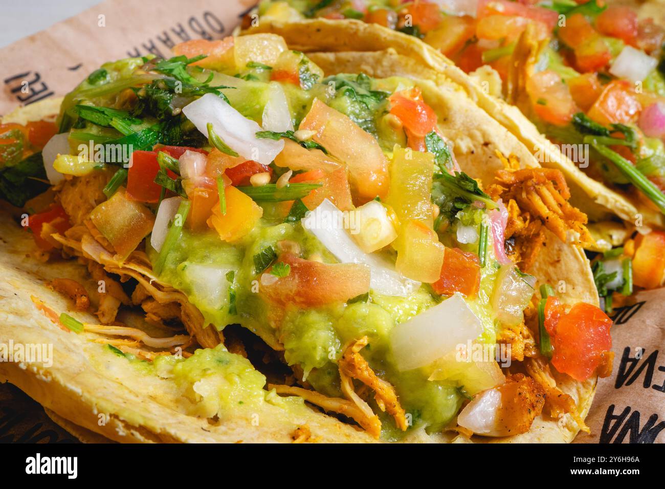 Two soft taco's with chicken and beans. laying down on brown paper ...