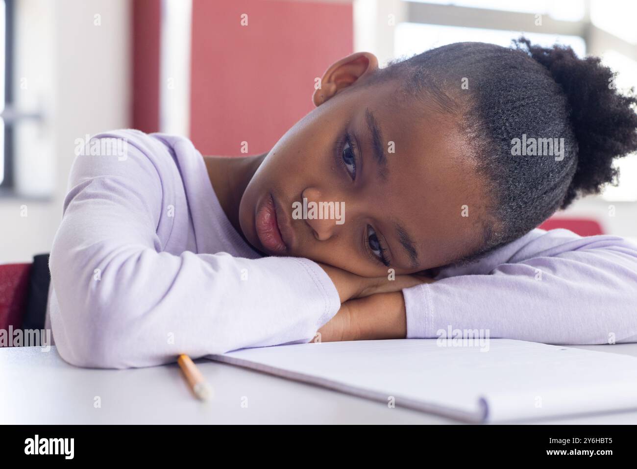 In school, african american girl resting head on desk with pencil and ...
