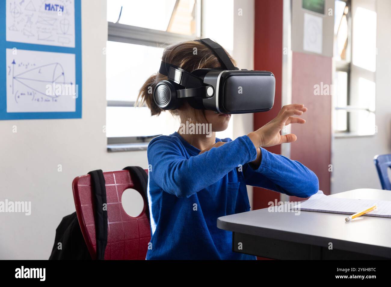 Using VR headset, boy interacting with virtual environment in school ...