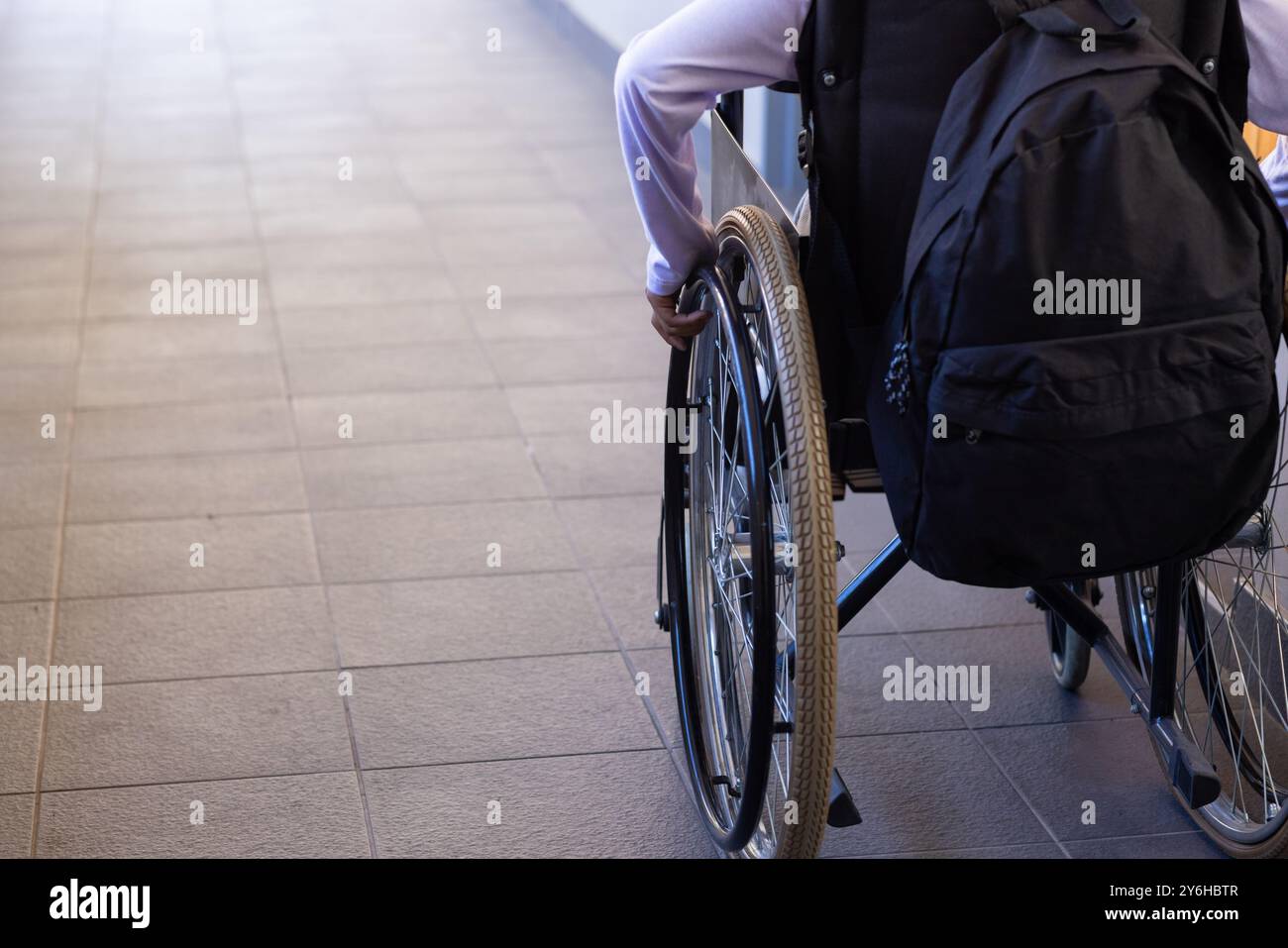 Navigating school hallway, african american girl in wheelchair with ...