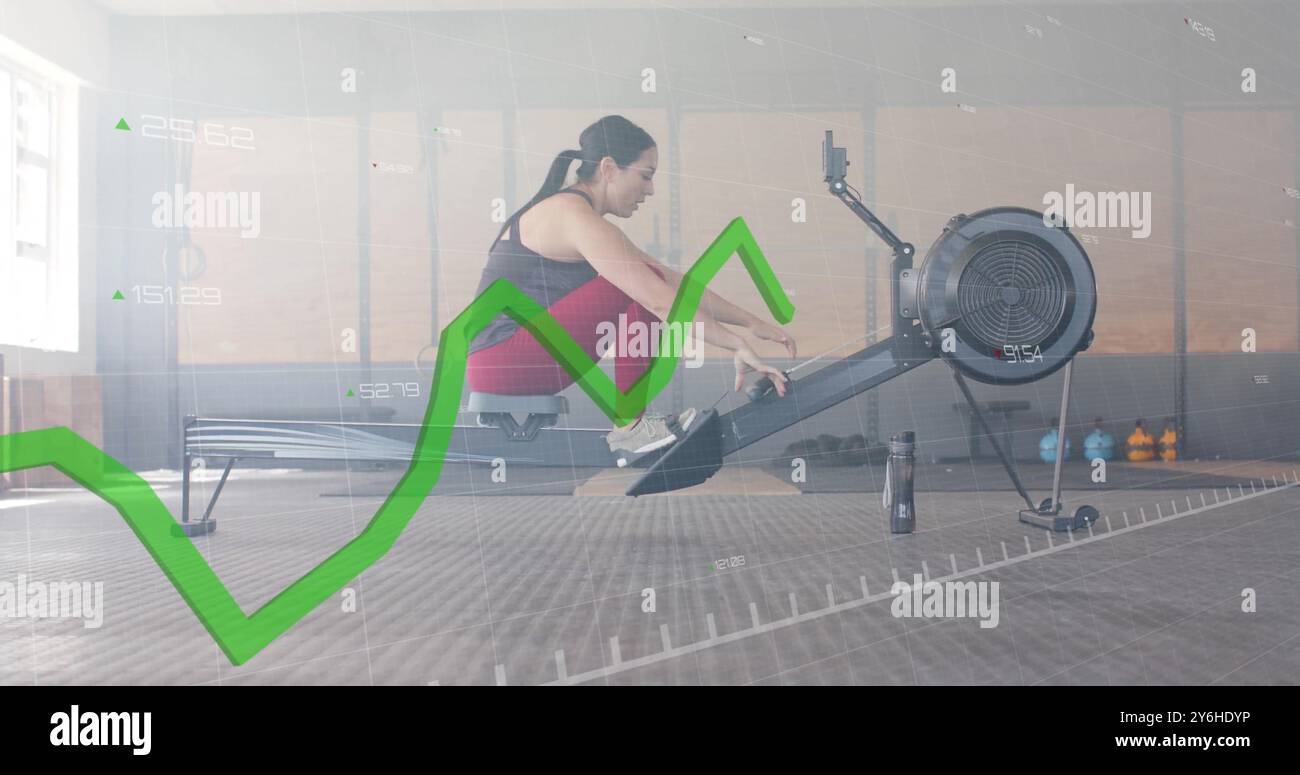 Exercising on rowing machine, woman with fitness data image over gym ...