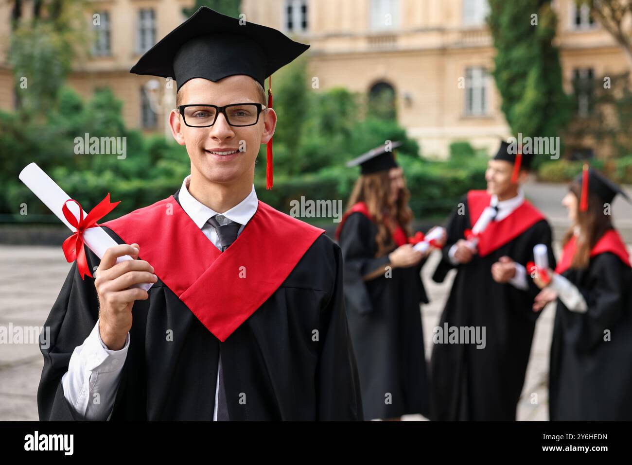 Happy students with diplomas after graduation ceremony outdoors ...
