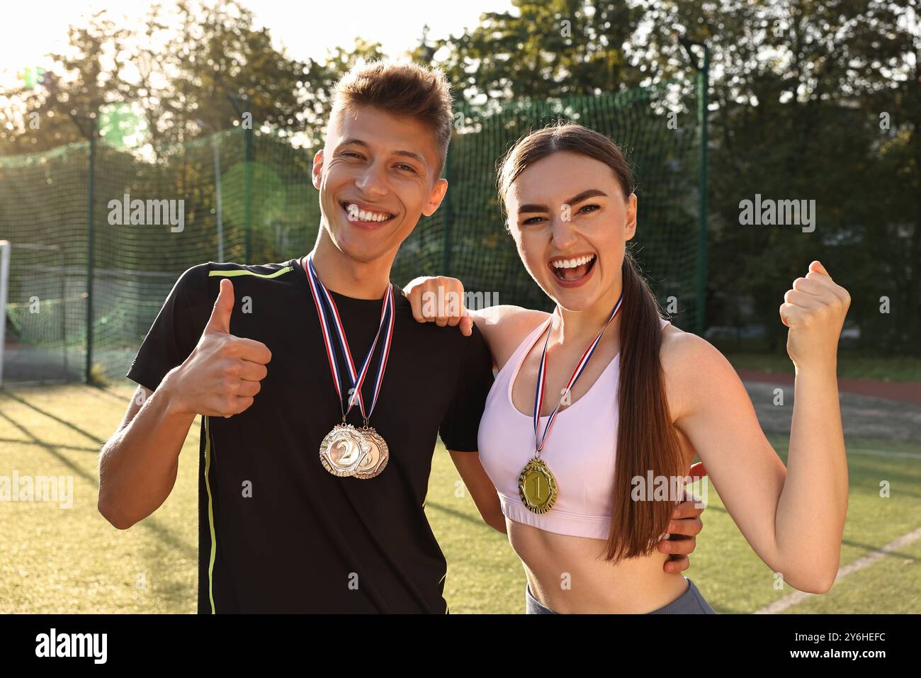 Portrait of happy winners with medals at stadium Stock Photo - Alamy