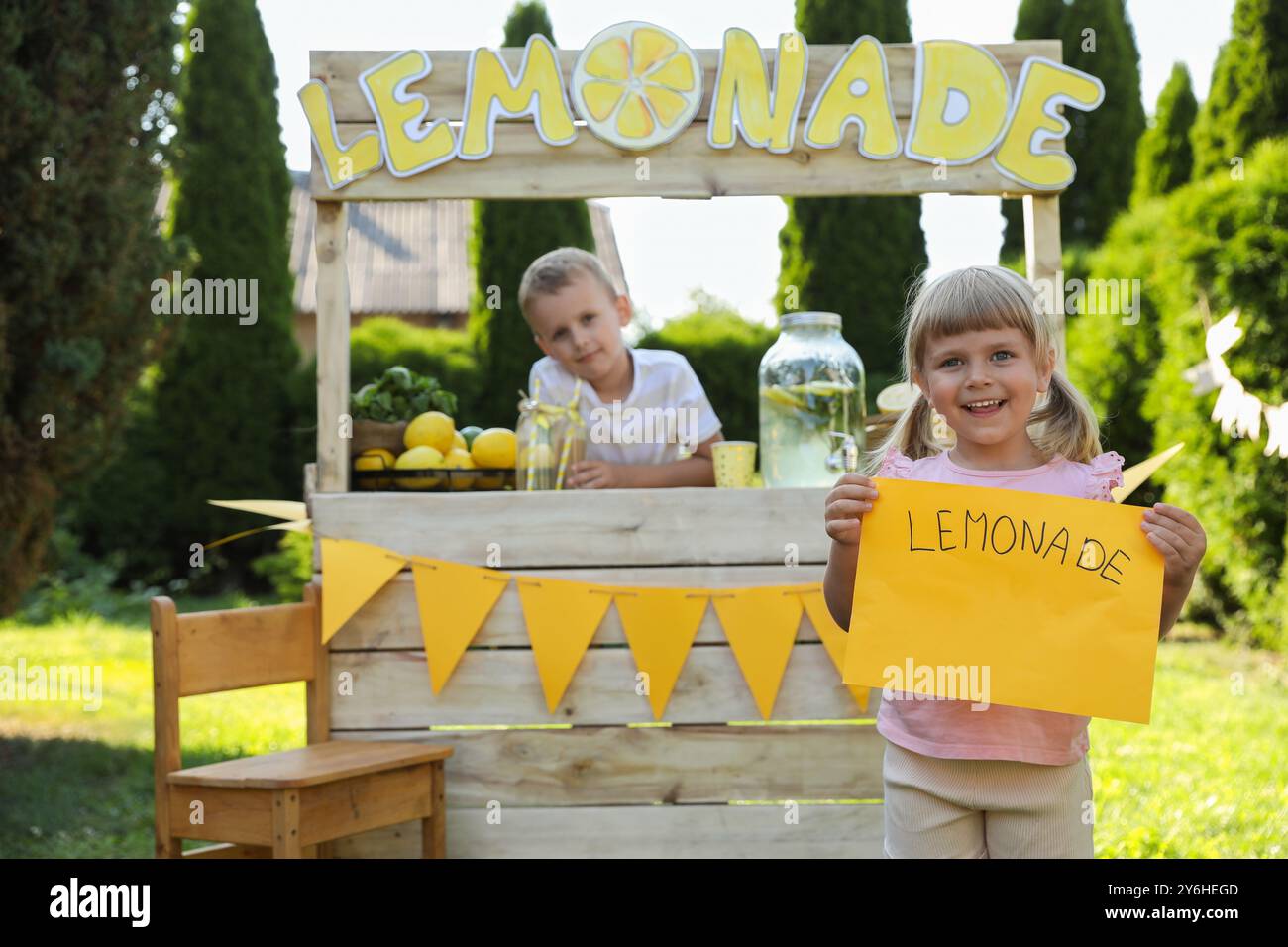 Little girl holding price tag near lemonade stand in park Stock Photo ...