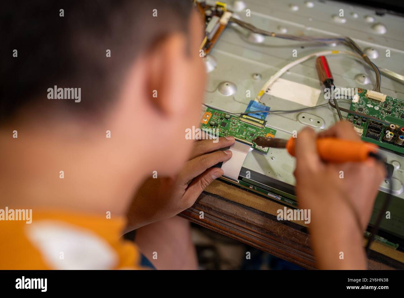 technician man uses soldering iron to replace electronic component ...