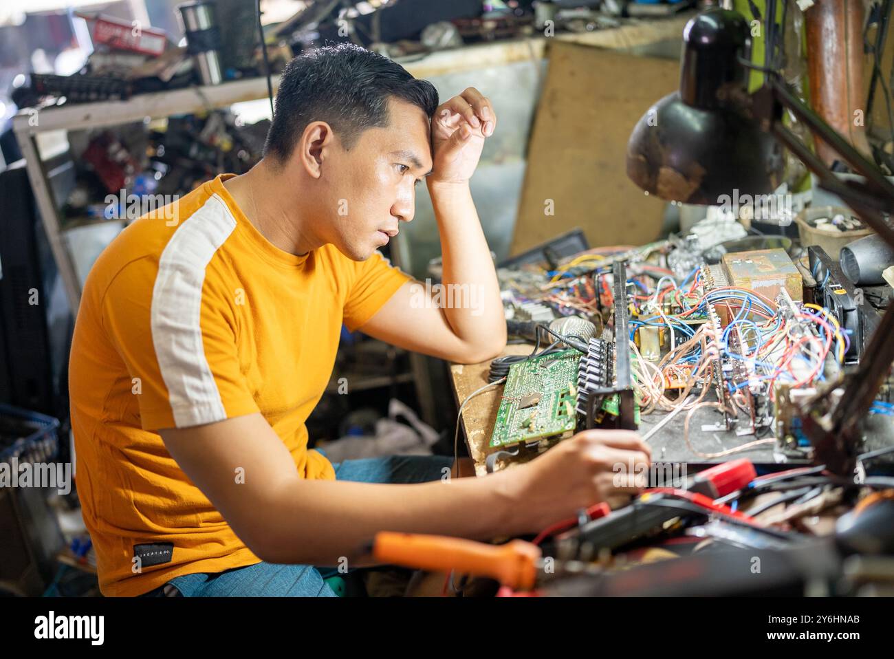 technician thinking hard about the complex circuitry of an electronic ...