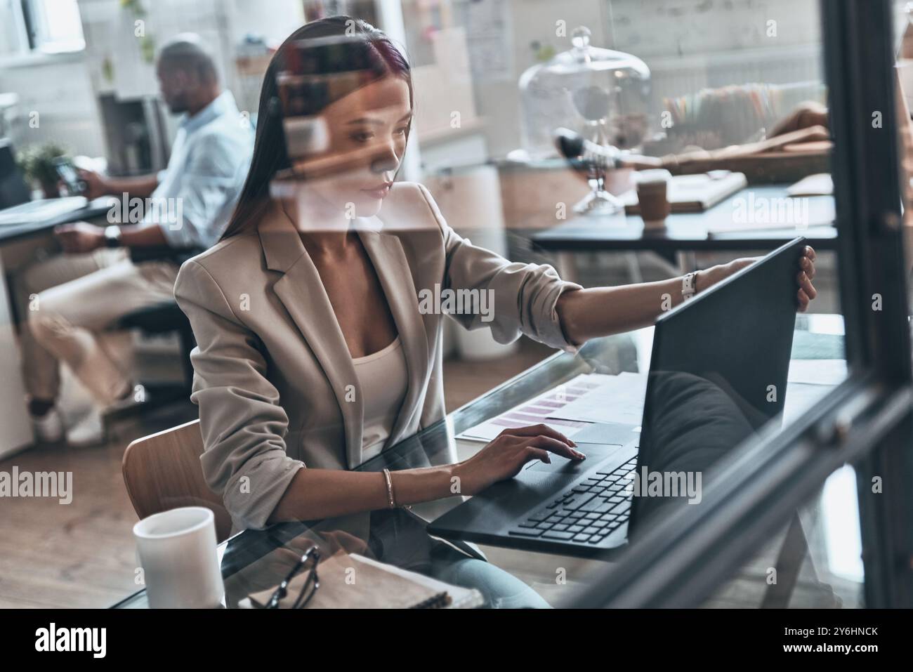 Analyzing data. Top view of modern young woman using computer while ...