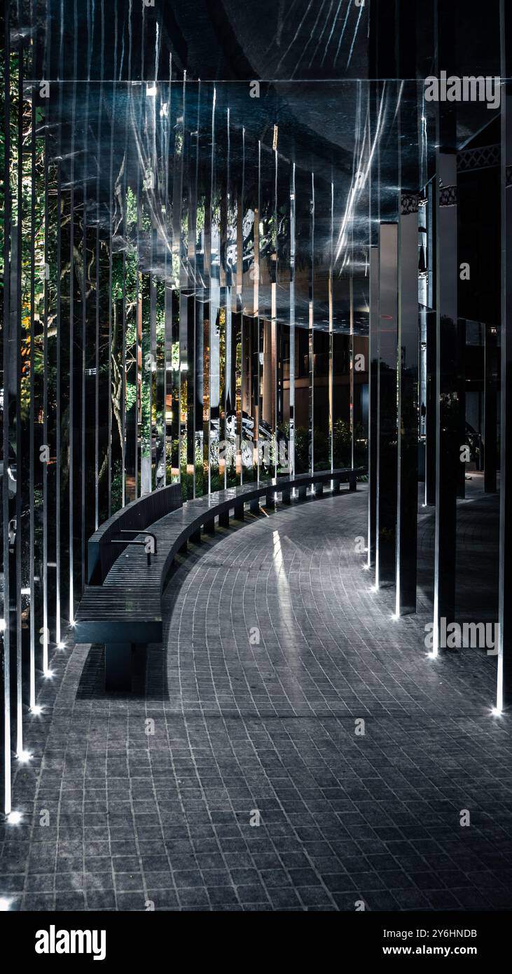 A modern architectural pathway surrounded by greenery at night with ...