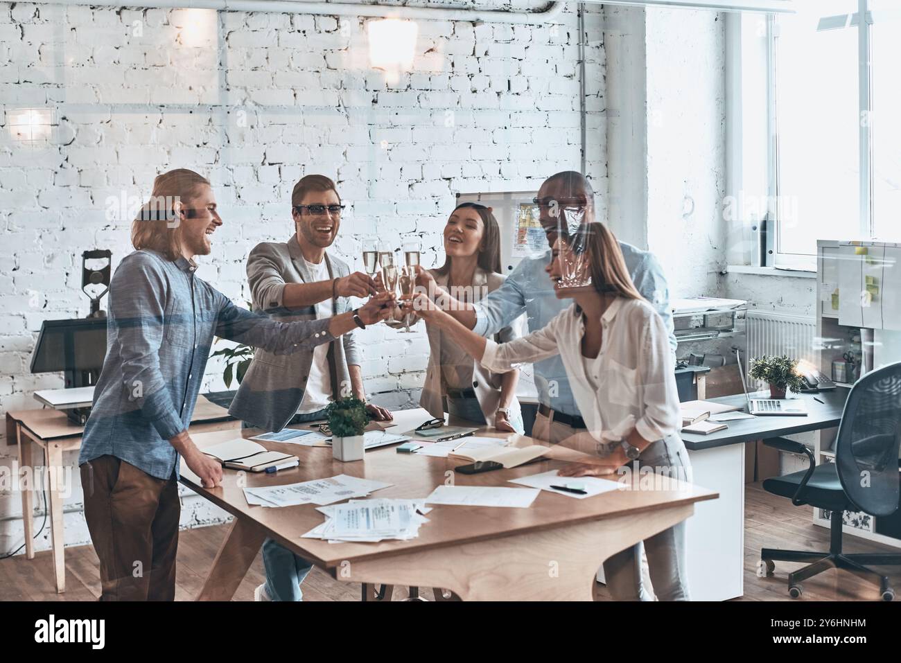 Toasting their success. Group of young business people toasting each ...