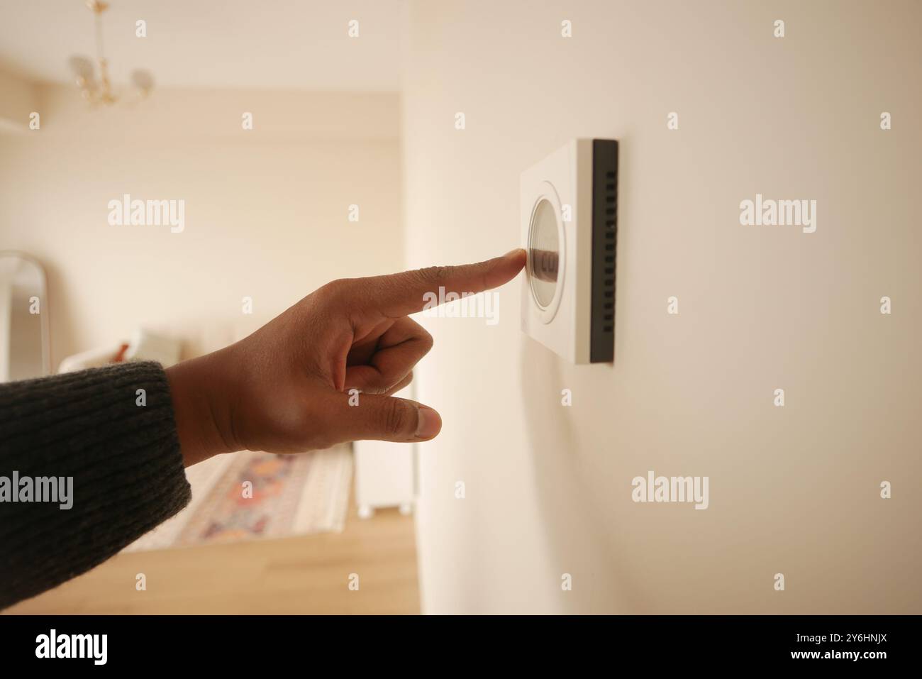 Hand Adjusting Smart Thermostat on White Wall for Optimal Home ...