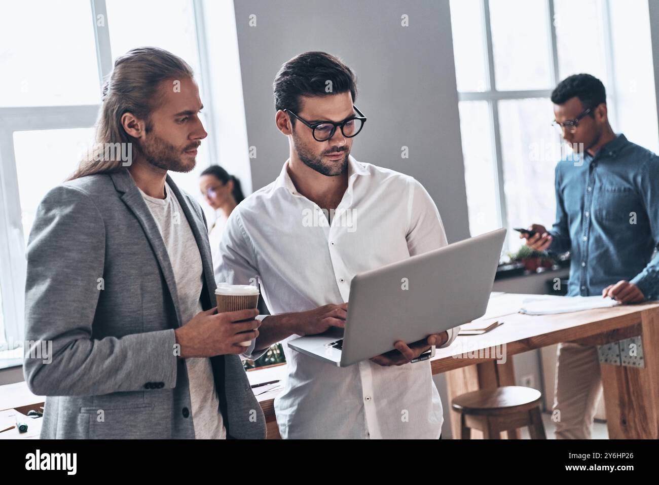 Discussing risky ideas. Two young modern men in smart casual wear using ...