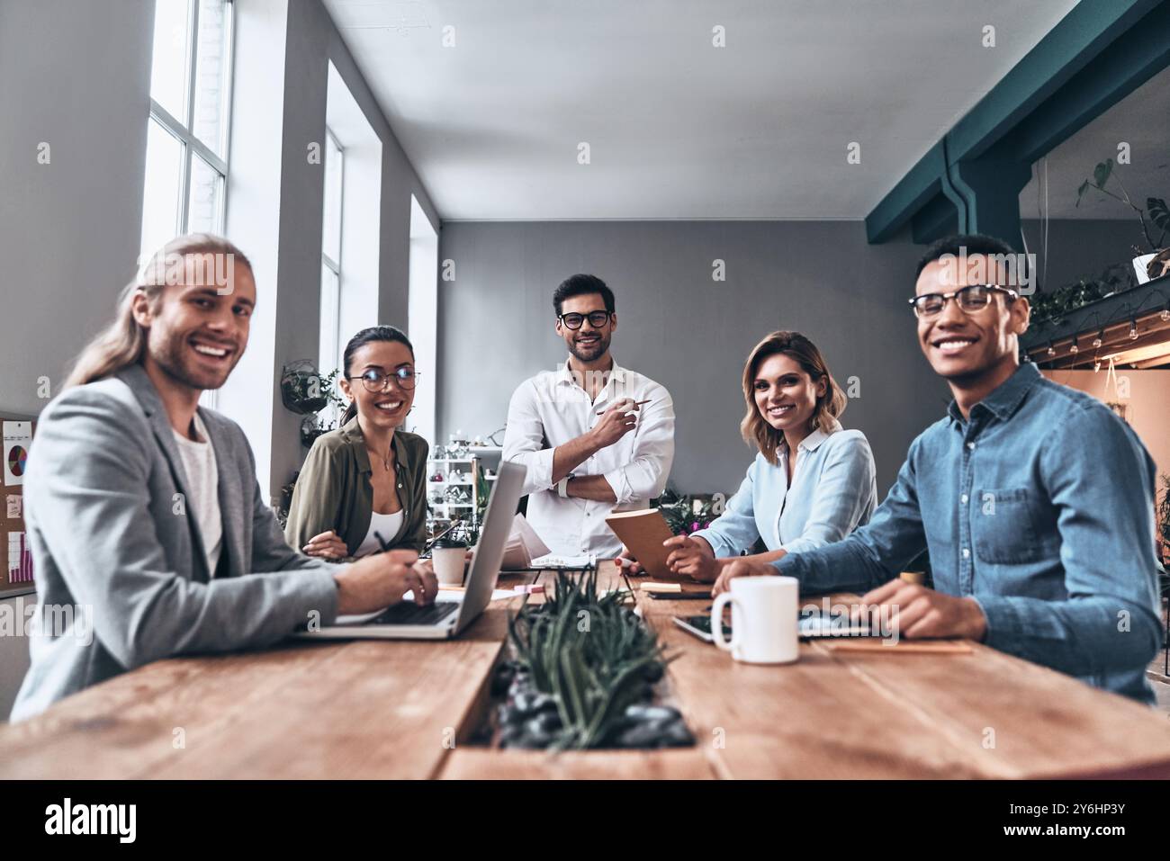 Happy to work together. Group of young modern people in smart casual ...
