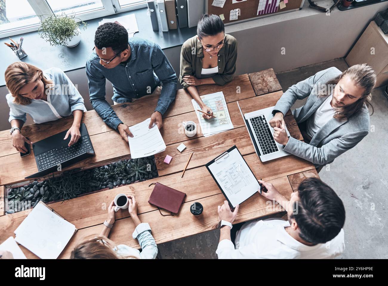 Busy working day. Top view of young modern people in smart casual wear ...
