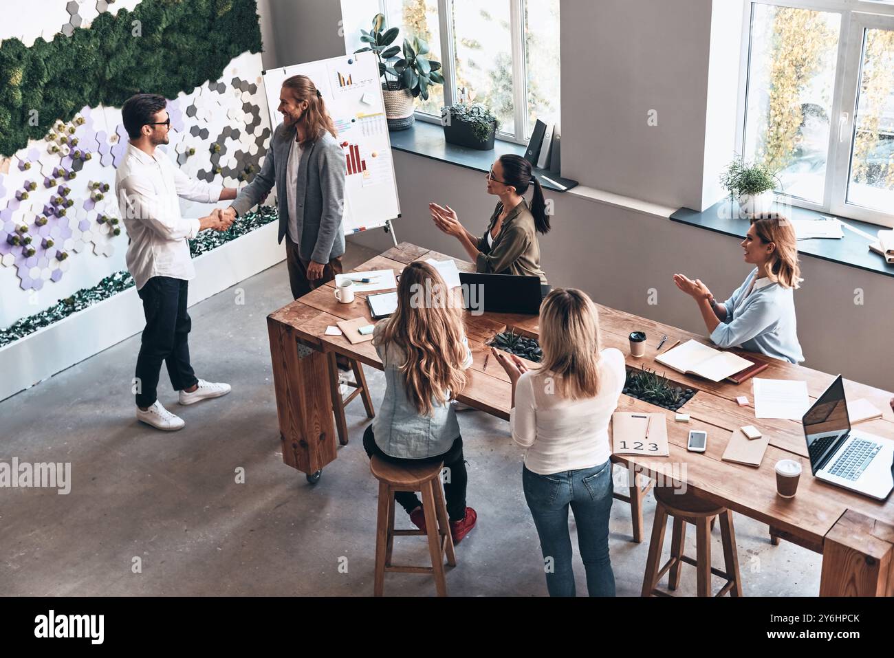 Great presentation. Top view of two modern young men shaking hands and ...