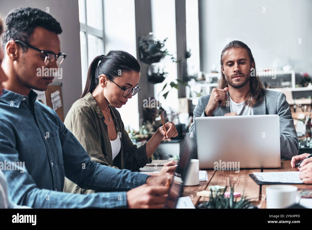 Concentrated at work. Group of serious young people working while ...