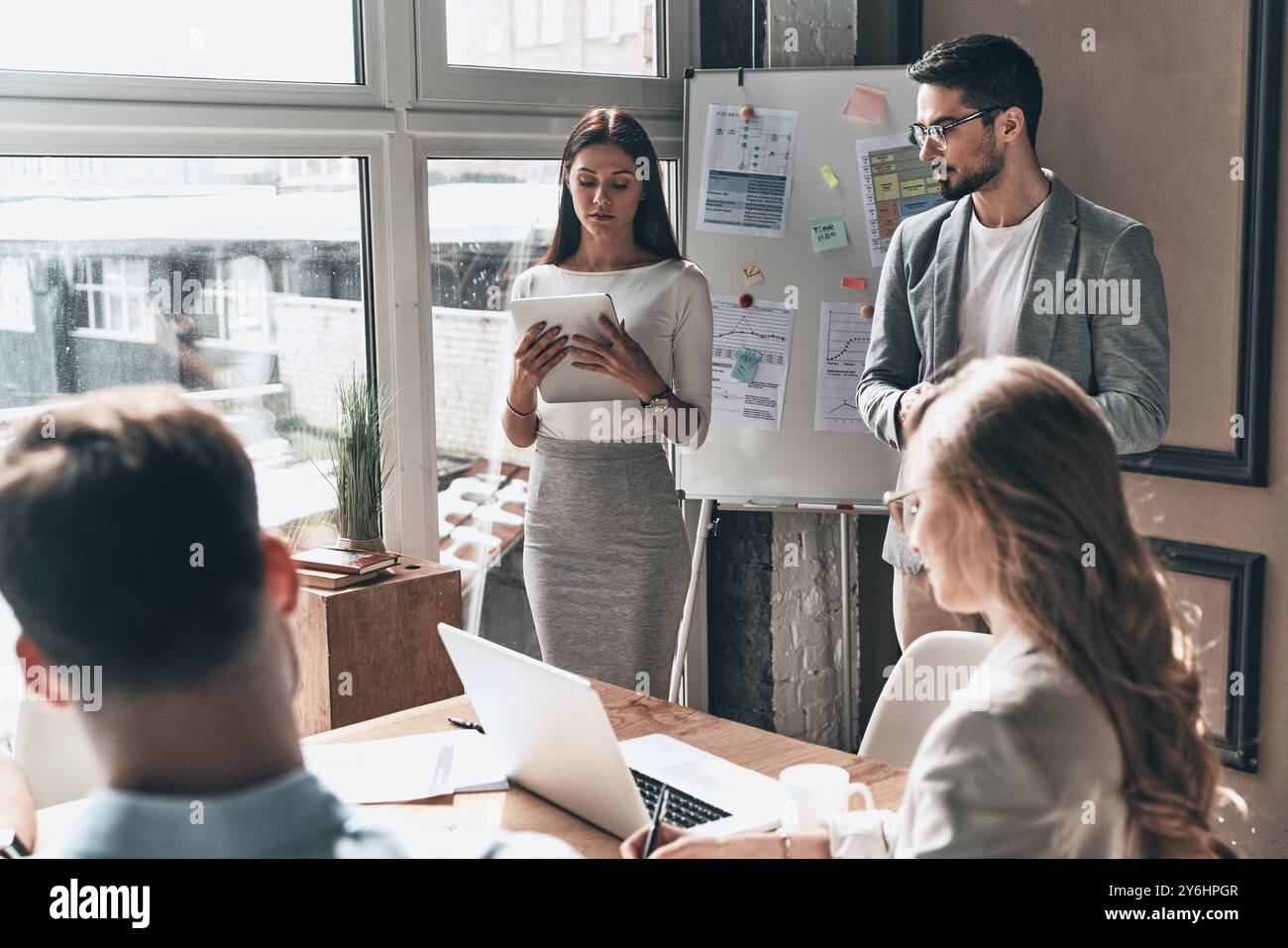 Talking business details. Two young colleagues conducting a business ...