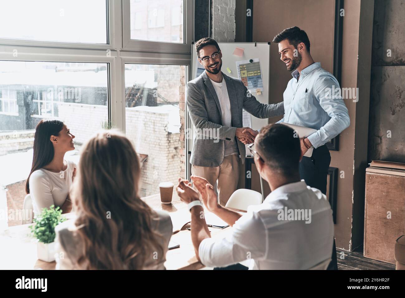 Project well done. Group of business people clapping and smiling while ...