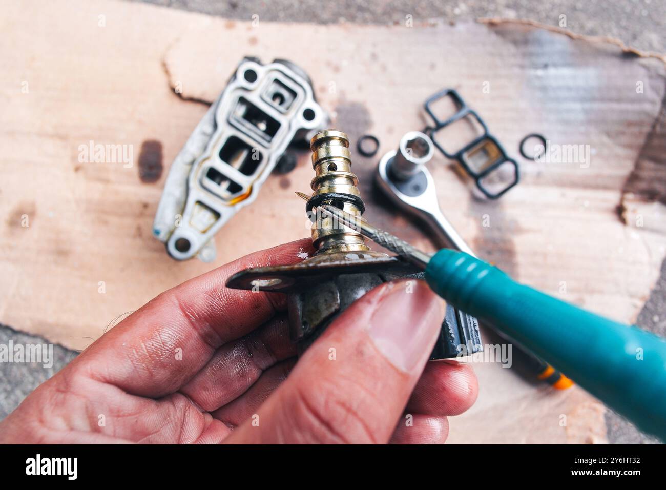A mechanic is replacing a worn out rubber seal to repair a car engine ...