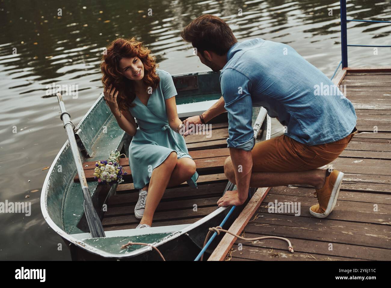 Romantic date. Happy young couple getting ready to row a boat while ...