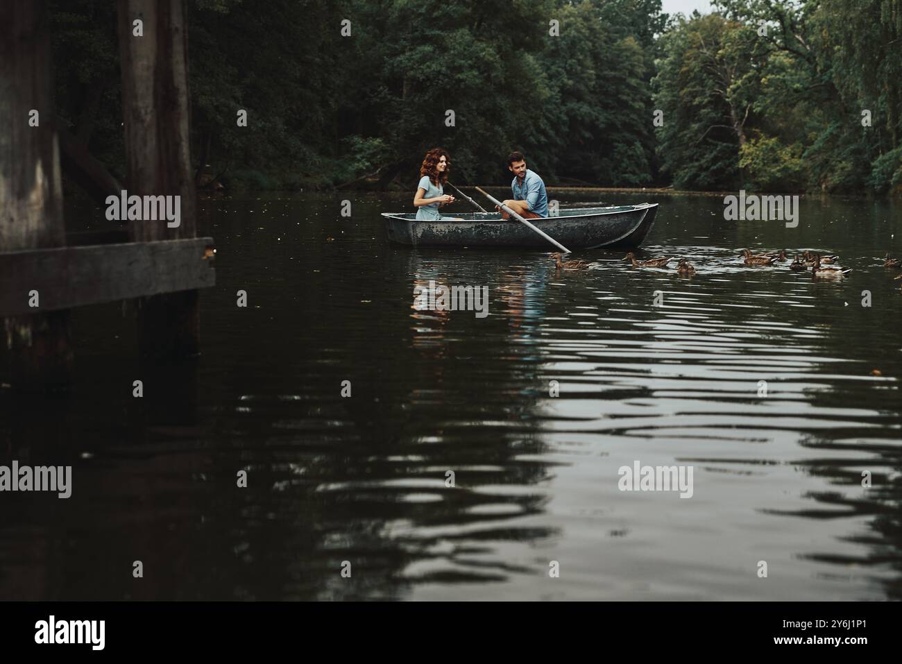 Real love. Beautiful young couple smiling and feeding ducks while ...