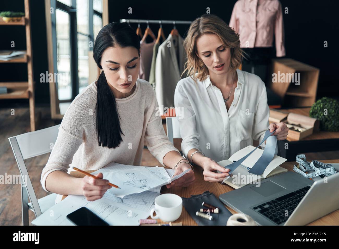 Concentrated on work. Beautiful young women working on sketches and ...