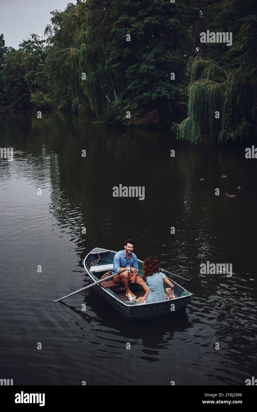 Getting away from... Top view of beautiful young couple feeding ducks ...