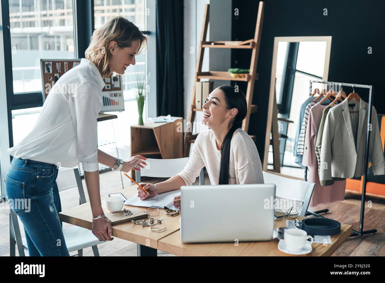 Sharing opinions. Beautiful young women working together and smiling ...
