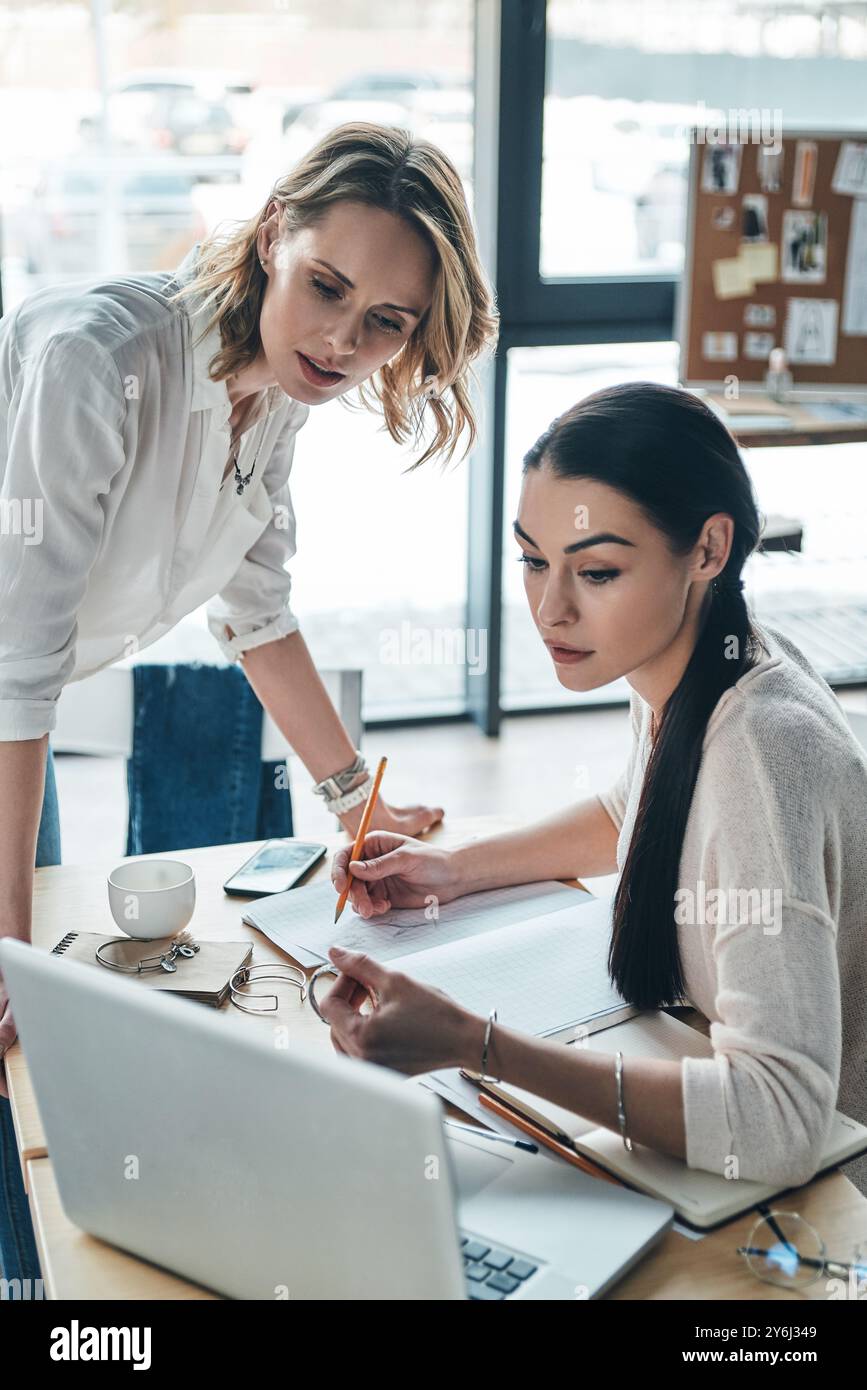 Working through some concepts. Beautiful young women working together ...