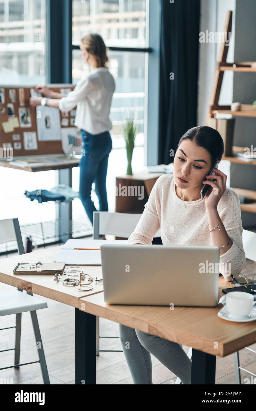 Another busy day. Beautiful young women working together while spending ...