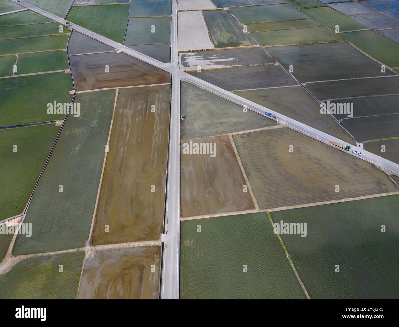 Aerial view of intersecting roads and agricultural fields, showcasing a ...