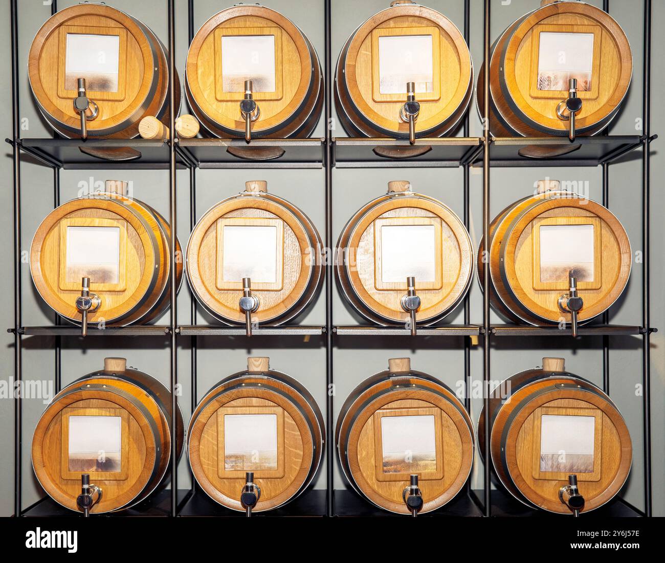 Wooden barrels arranged on metal racks in a brewery, distillery storage ...