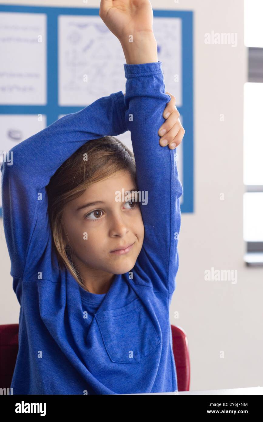 In school, boy raising hand in classroom, participating in lesson Stock ...