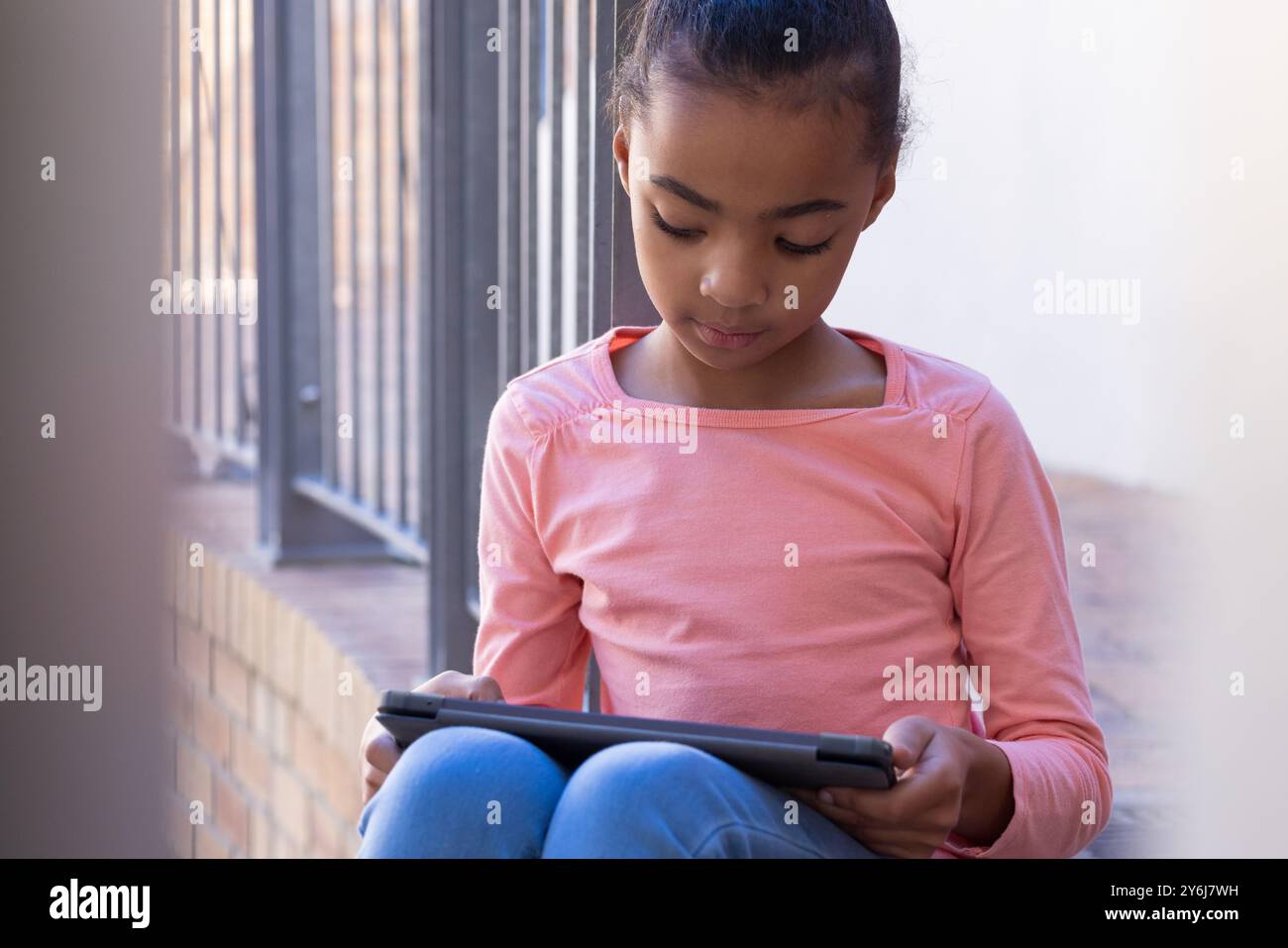 Using tablet, girl studying in school, sitting and focusing on screen ...