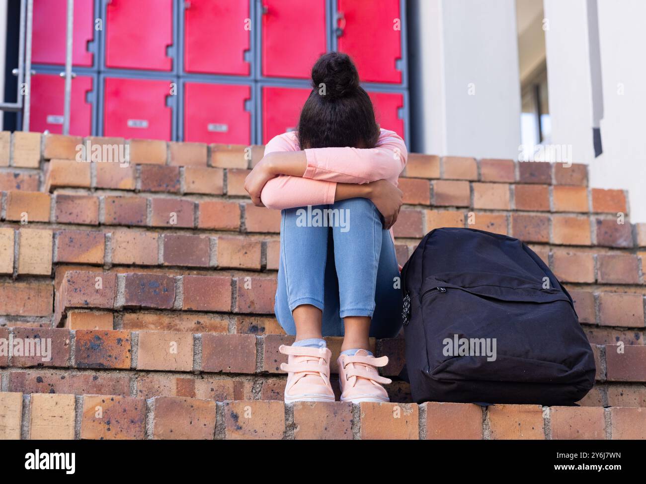 Sitting on school steps, african american girl with backpack feeling ...