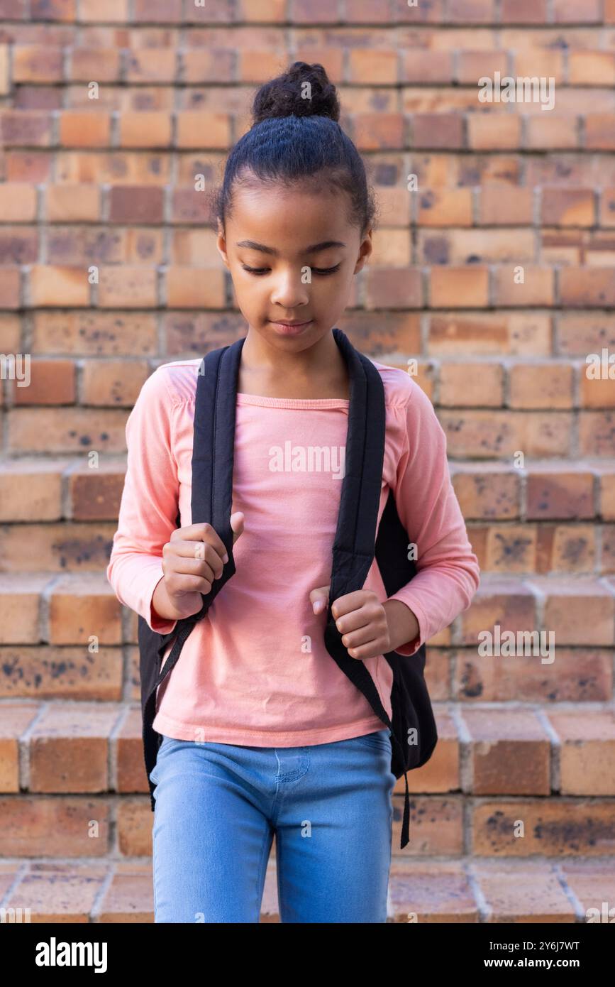 Walking down stairs, african american girl with backpack heading to ...