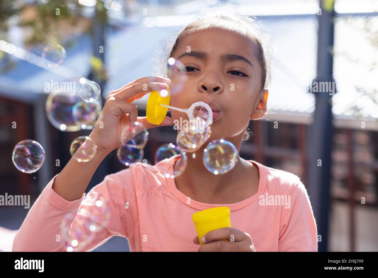 Blowing bubbles, african american girl enjoying outdoor activity in ...