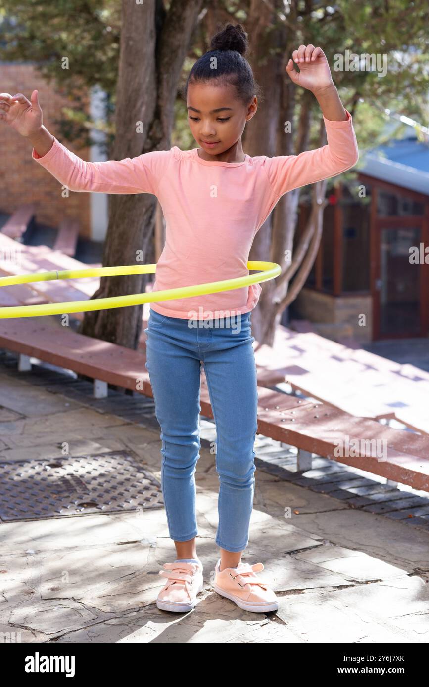 Playing with hula hoop, african american girl enjoying outdoor activity ...